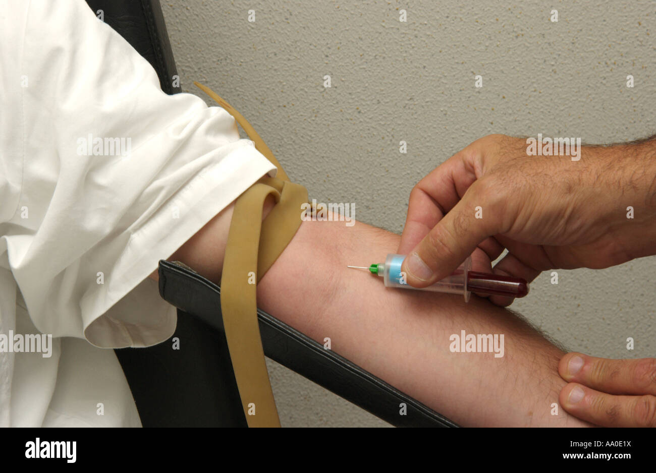 A healthcare worker is carefully drawing blood from a patient's arm ...