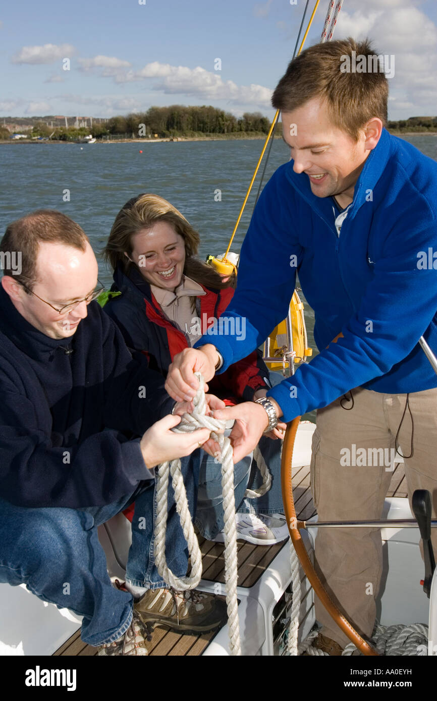 Sailing Instructor teaching the rudiments of tying knots to students on ...
