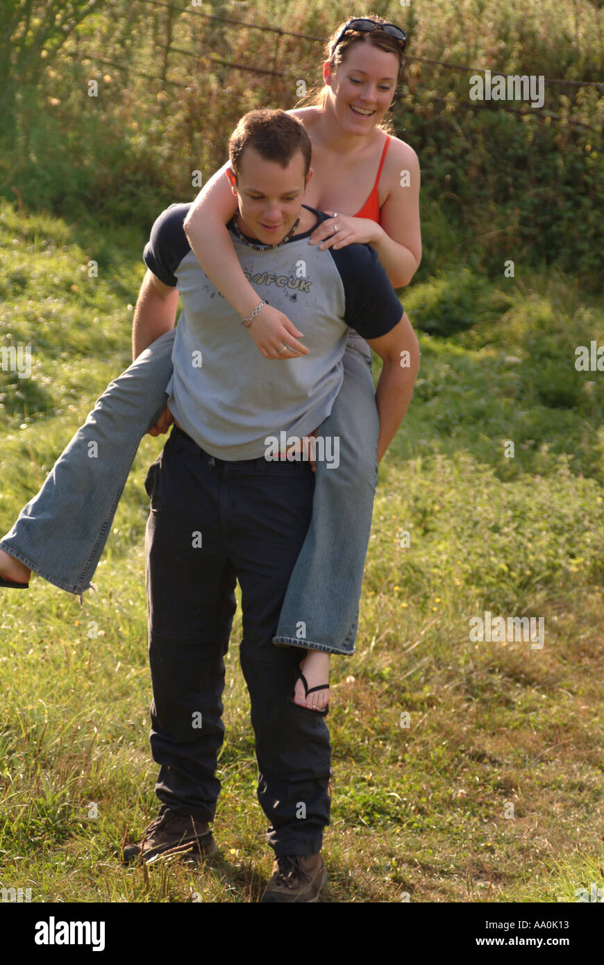 Man giving a woman a piggyback ride in the countryside Stock Photo - Alamy