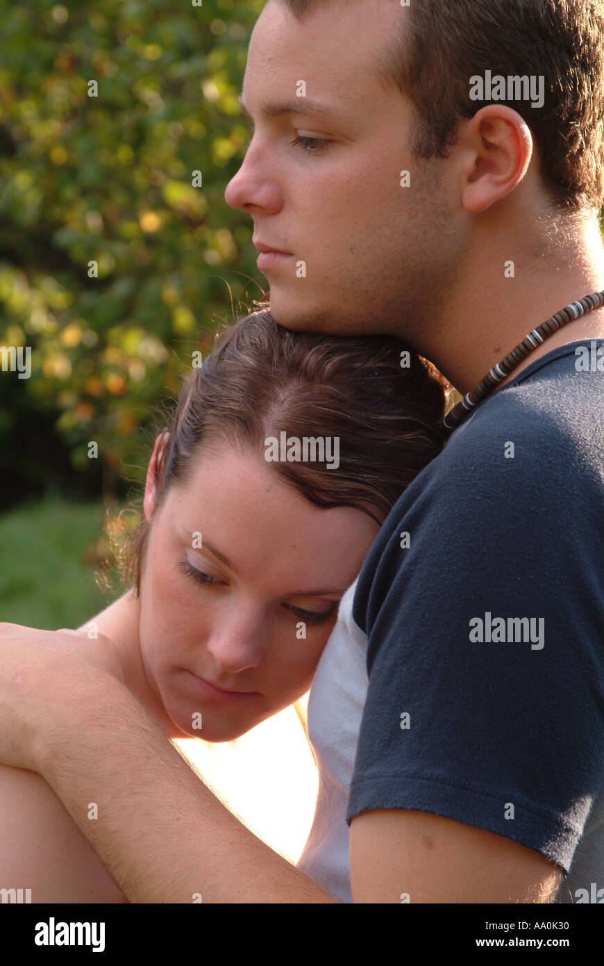 Couple embracing and looking sad Stock Photo - Alamy