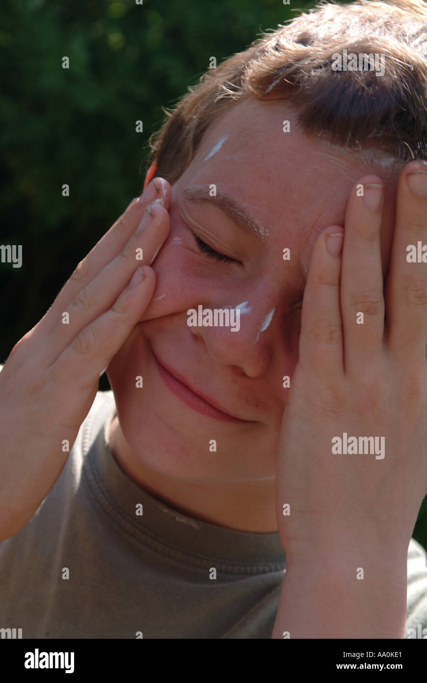 Young boy applying sunscreen to his face Stock Photo - Alamy