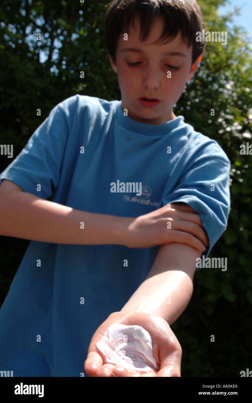 Young boy applying sunscreen to his body Stock Photo - Alamy