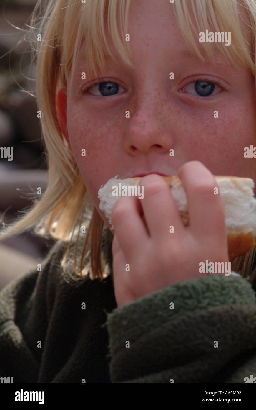 Little girl eating a bread roll Stock Photo - Alamy