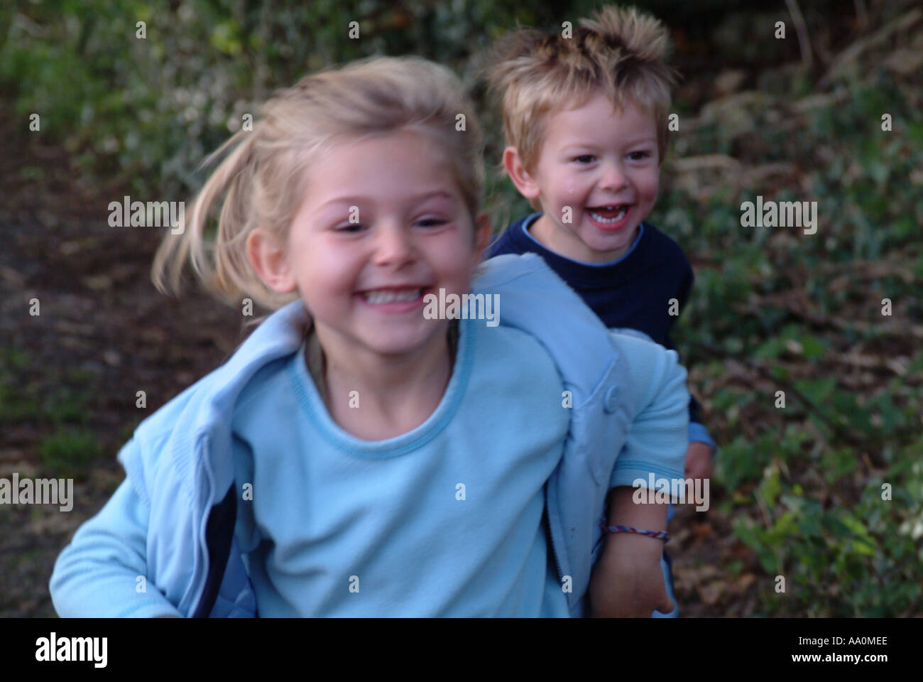 Two little children running outside Stock Photo - Alamy