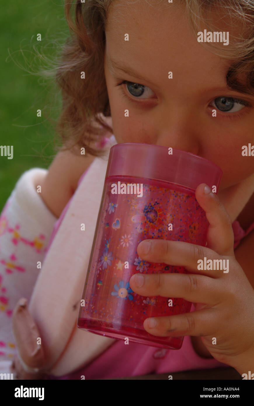 Little girl drinking out of a beaker Stock Photo - Alamy