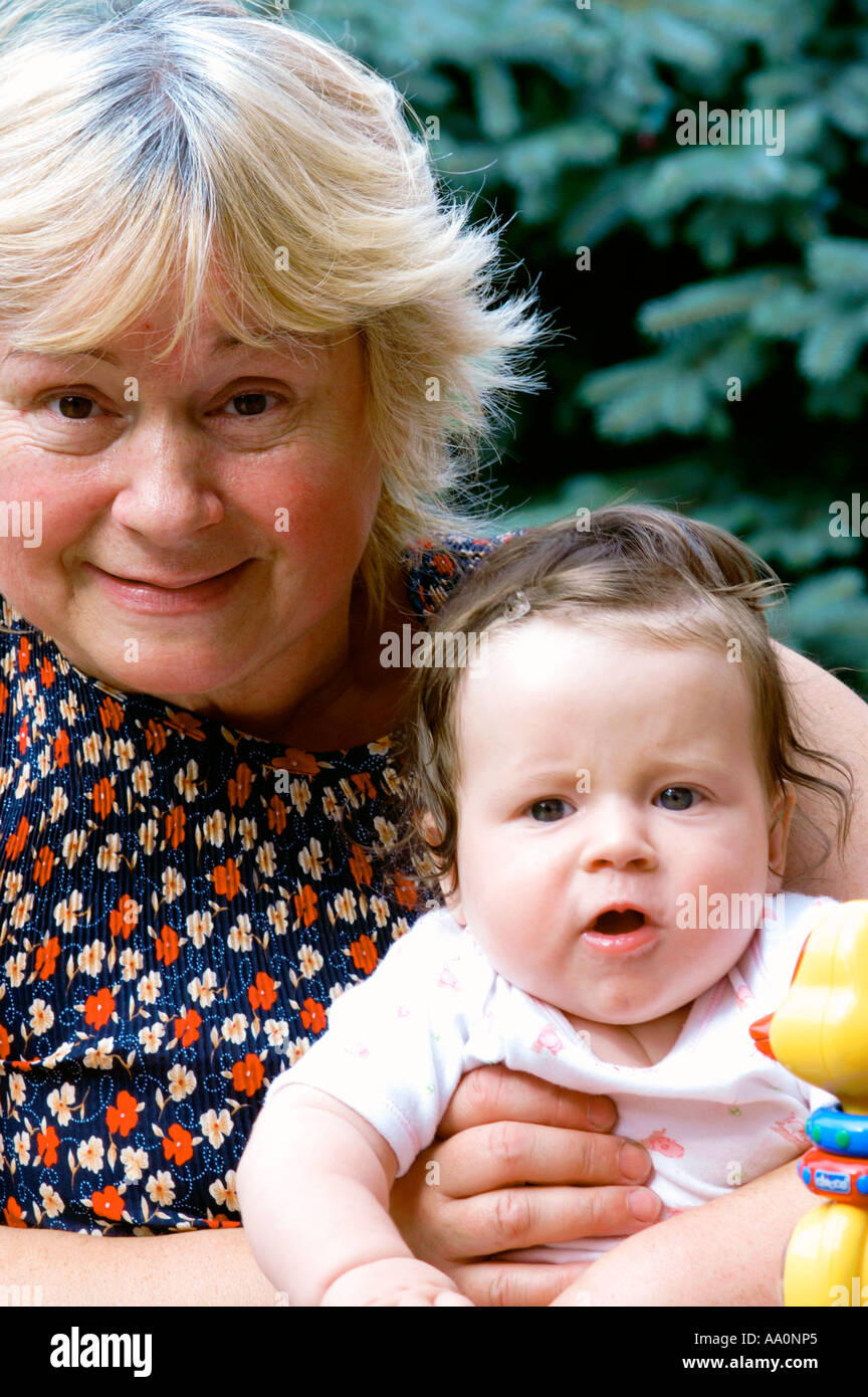Poland, Mature woman holding granddaughter (6-9 months) in garden ...