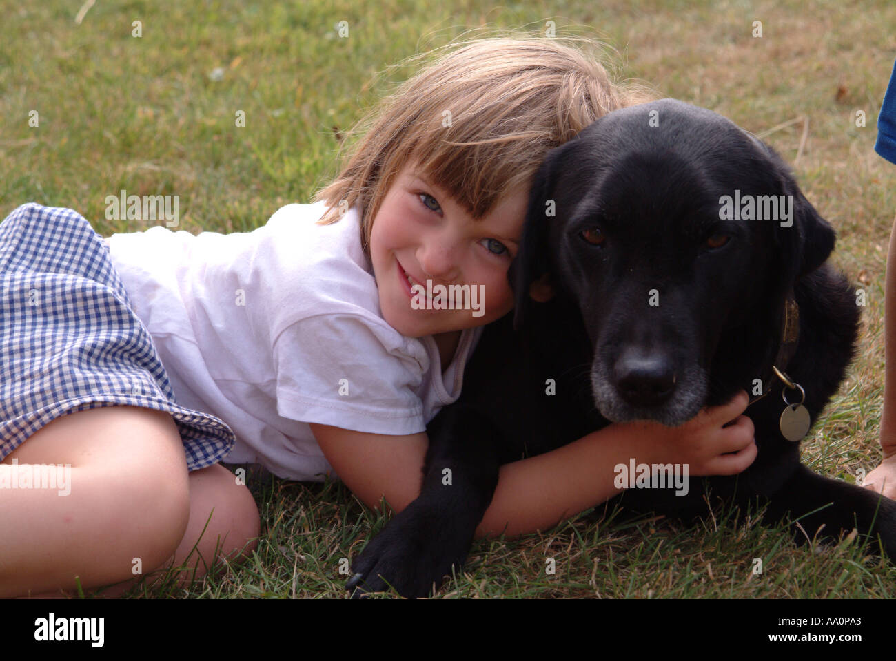 Little girl cuddling a dog Stock Photo - Alamy