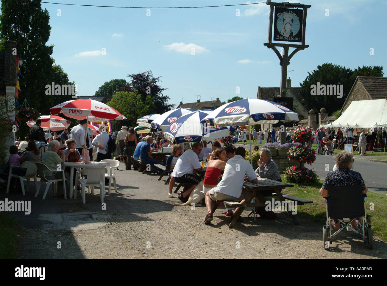 Lots of people sitting outside a pub, village fete Stock Photo - Alamy