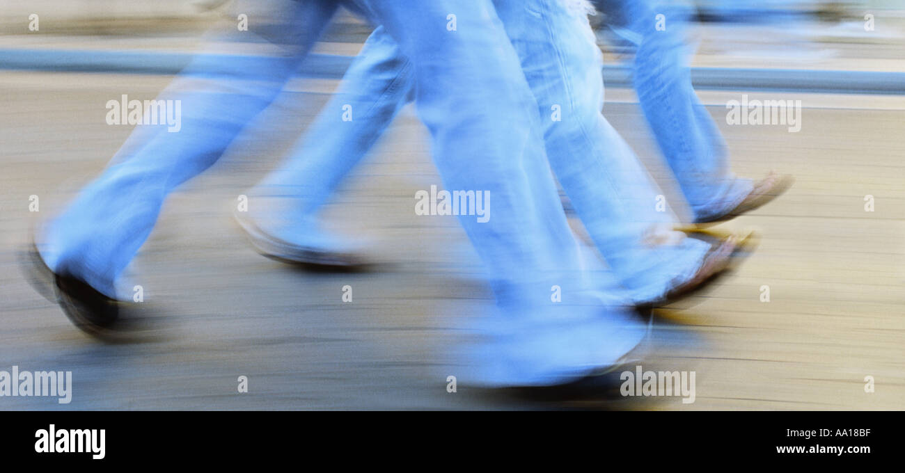 Three jeans clad teenage boys walking side by side in stride panned low ...