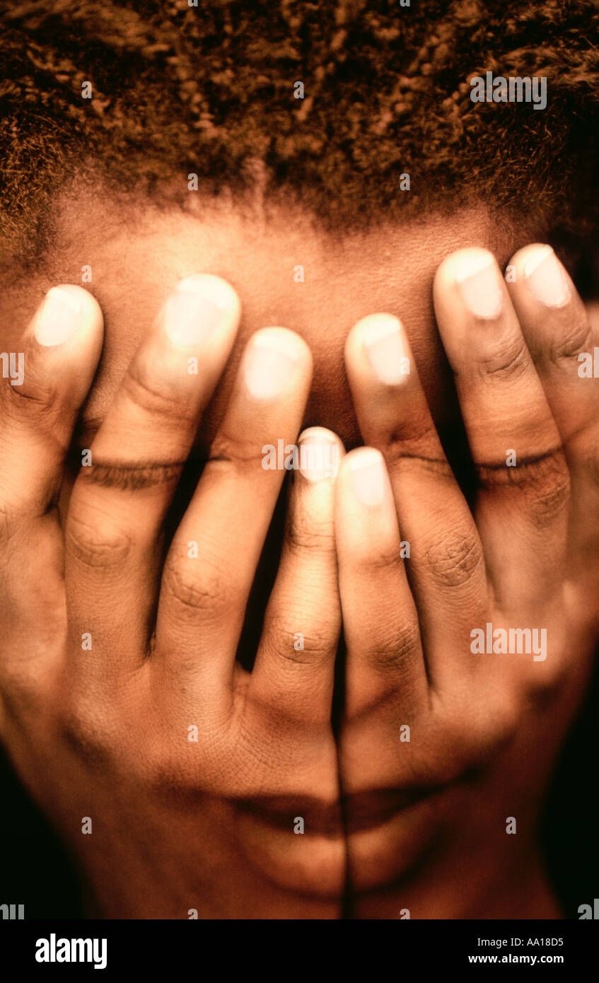 African American woman in 30 s with hands over face face showing ...