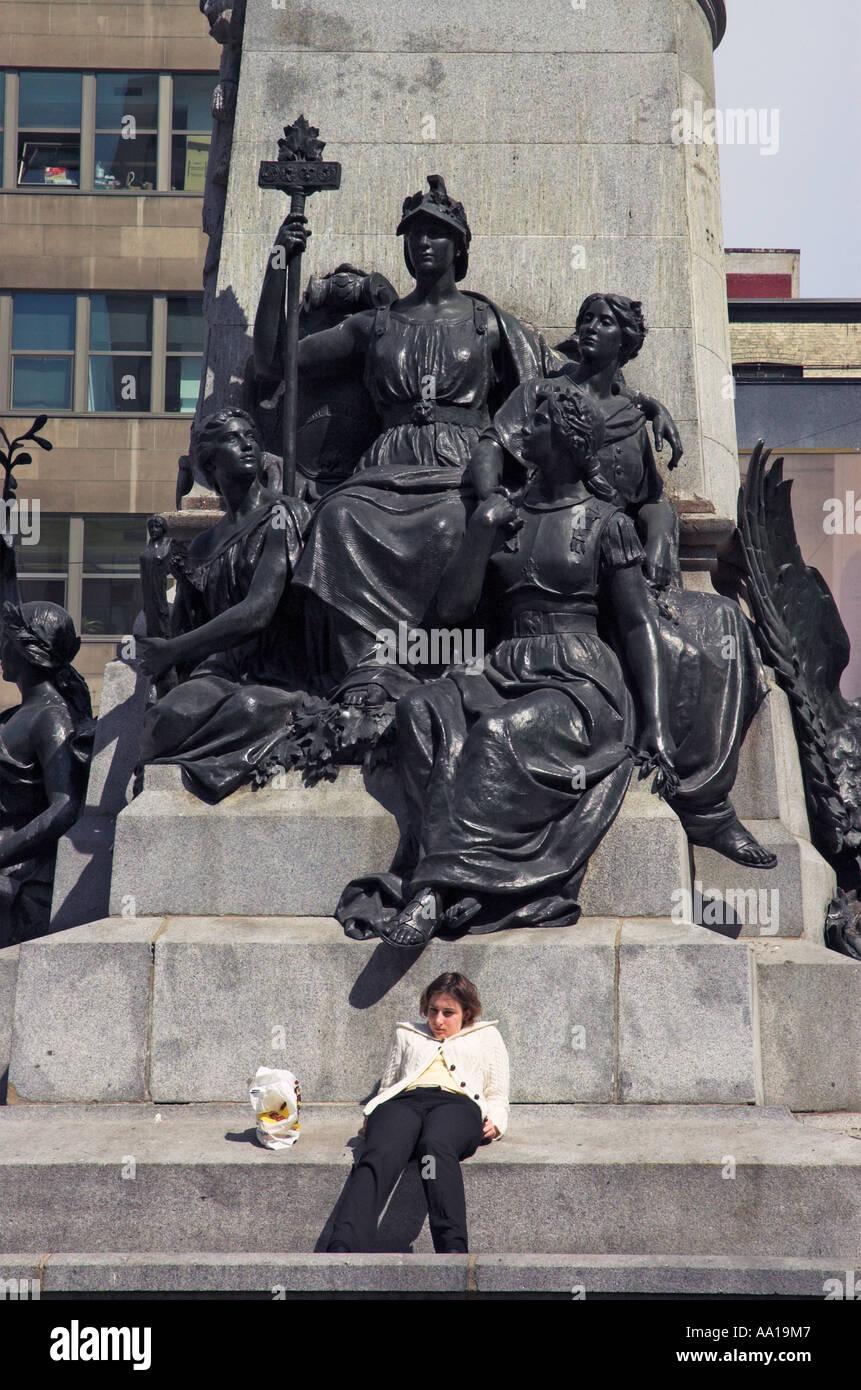 A bored looking girl sitting under a statue in Phillips Square Montreal ...