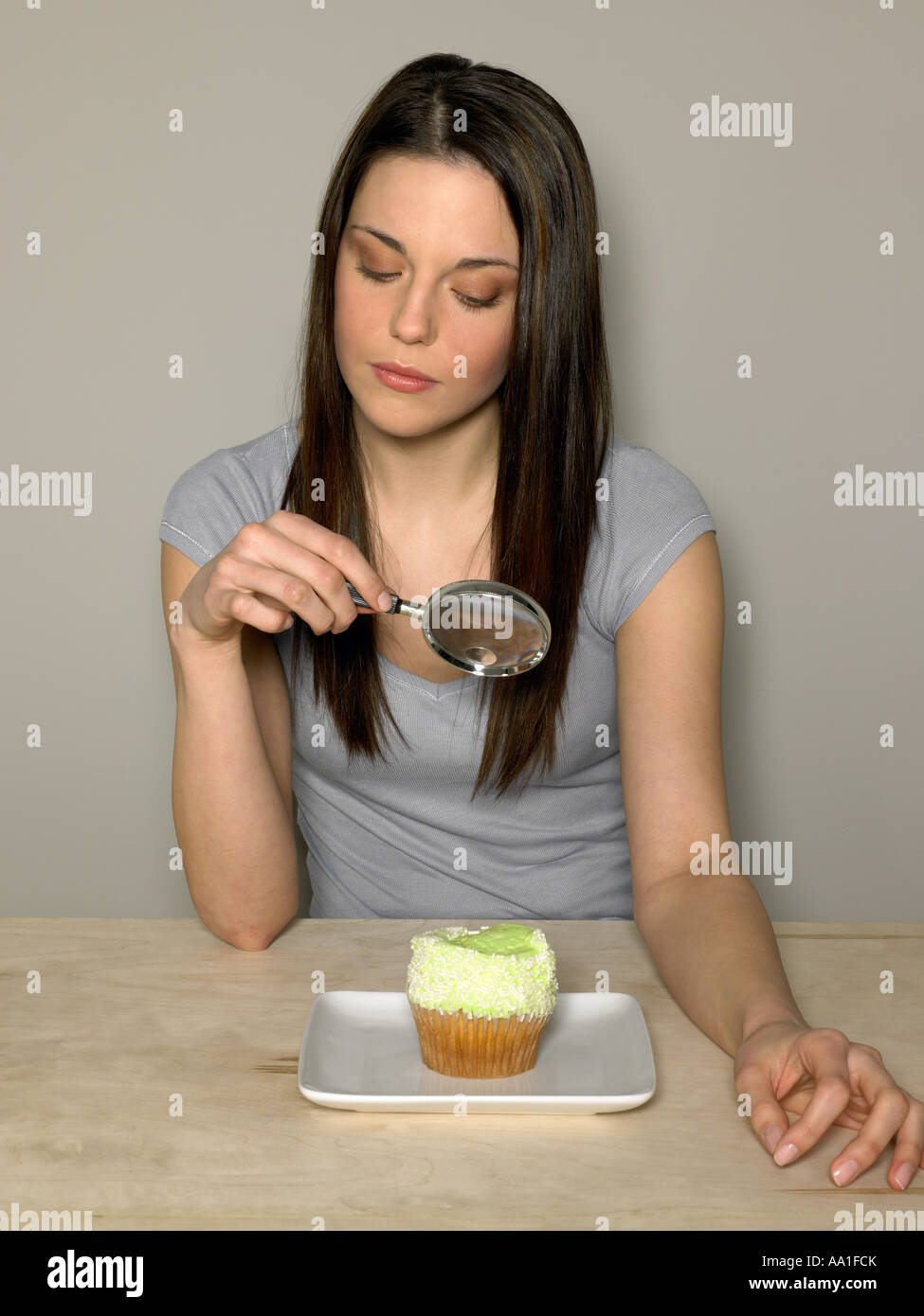 Young woman looking at cake with magnifying glass Stock Photo - Alamy