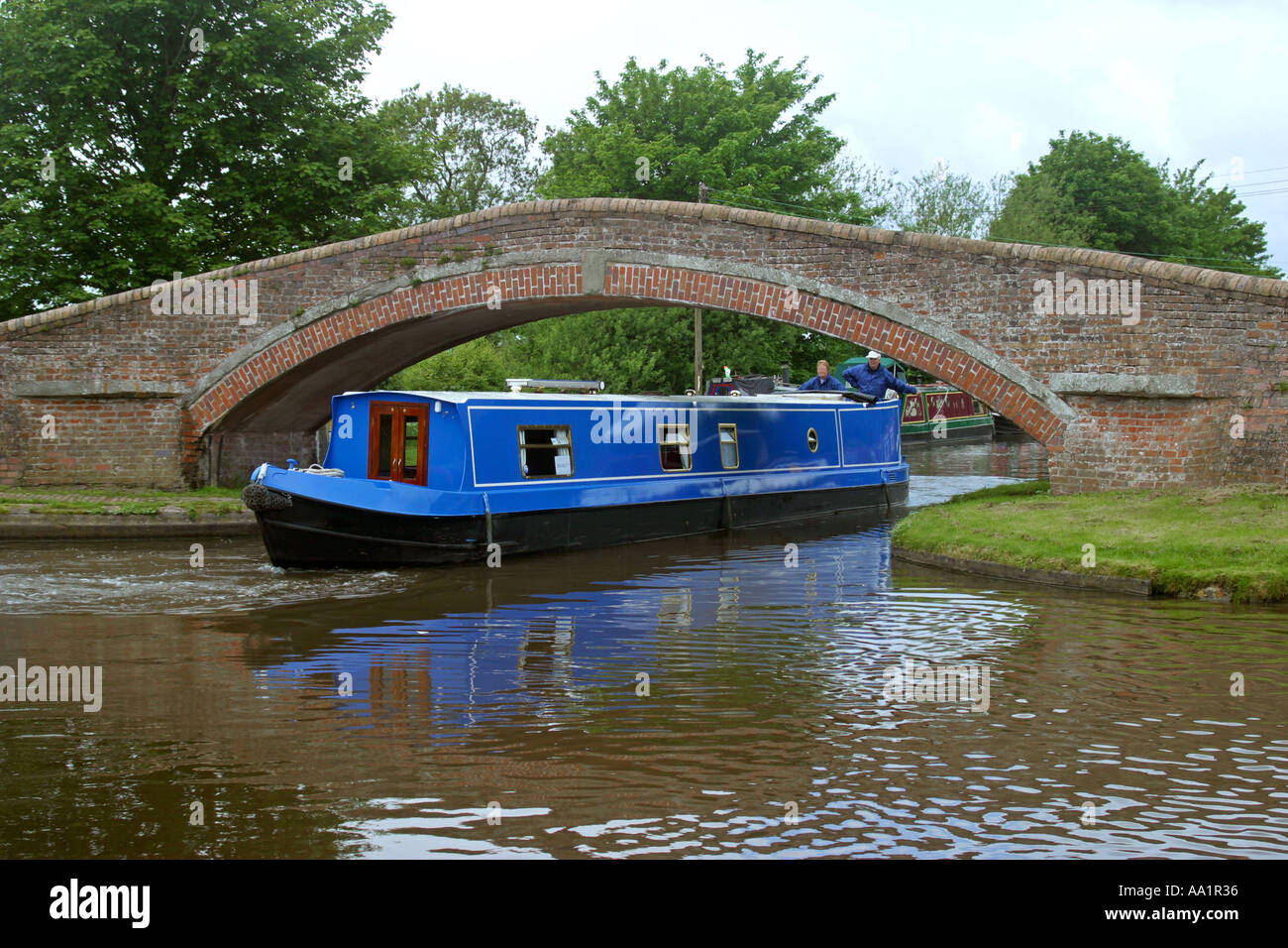 Canal boat under bridge at junction on waterway Stock Photo - Alamy