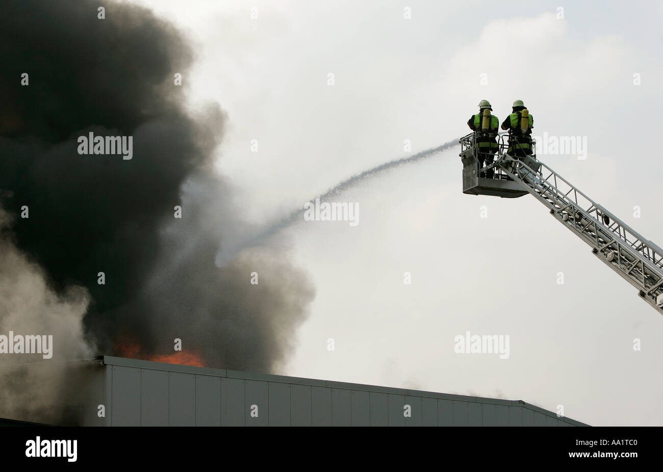 German fire brigade men fights a blaze in a warehouse in Munich Bavaria ...