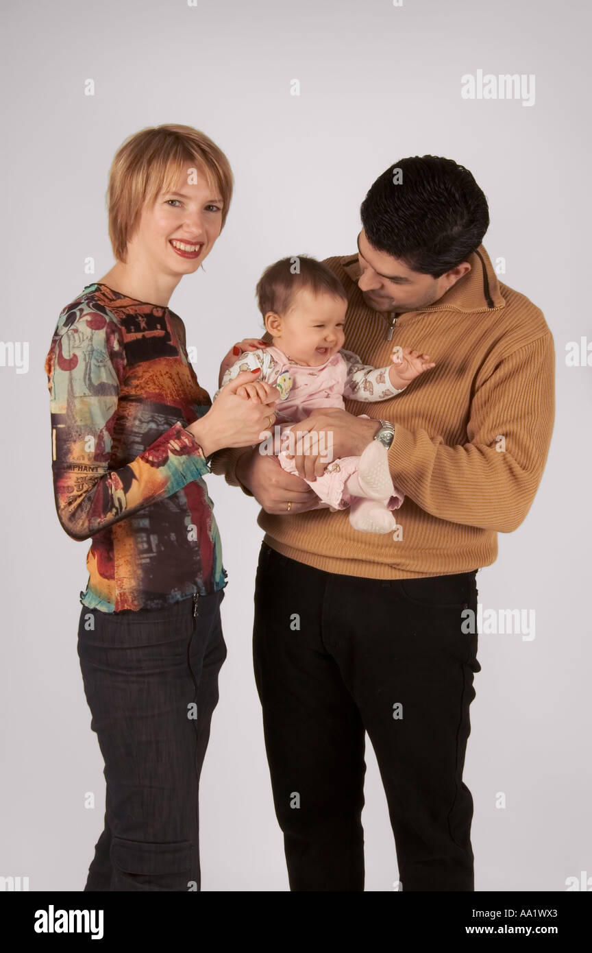 A man and woman standing with their child in their hands Stock Photo ...
