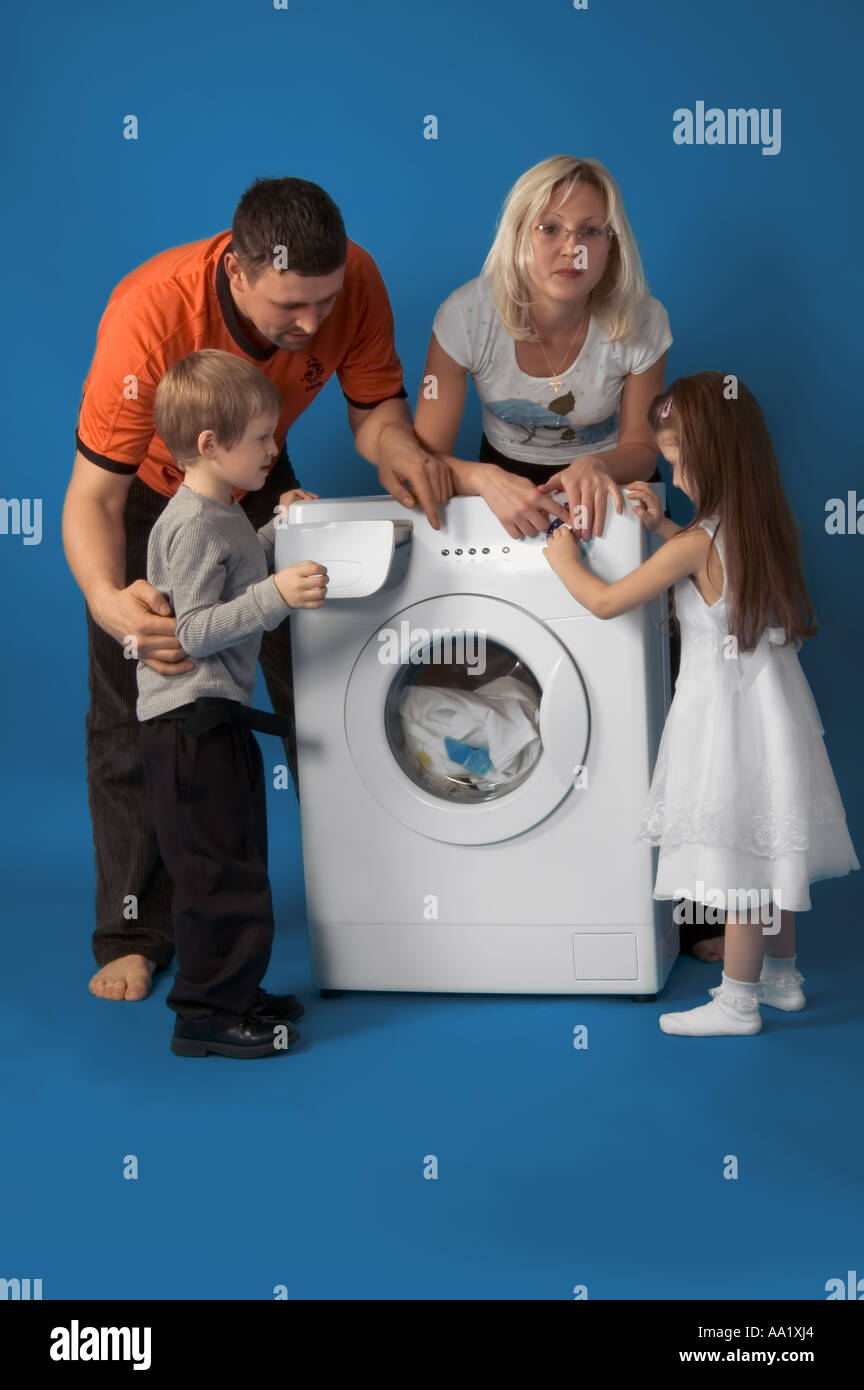 A family preparing the washing machine for work Stock Photo - Alamy