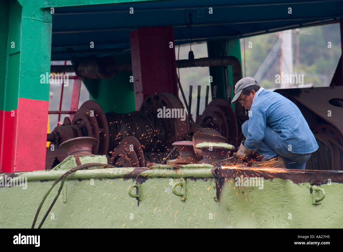 Shipyard welder working with acetylene torch fixing huge container ...
