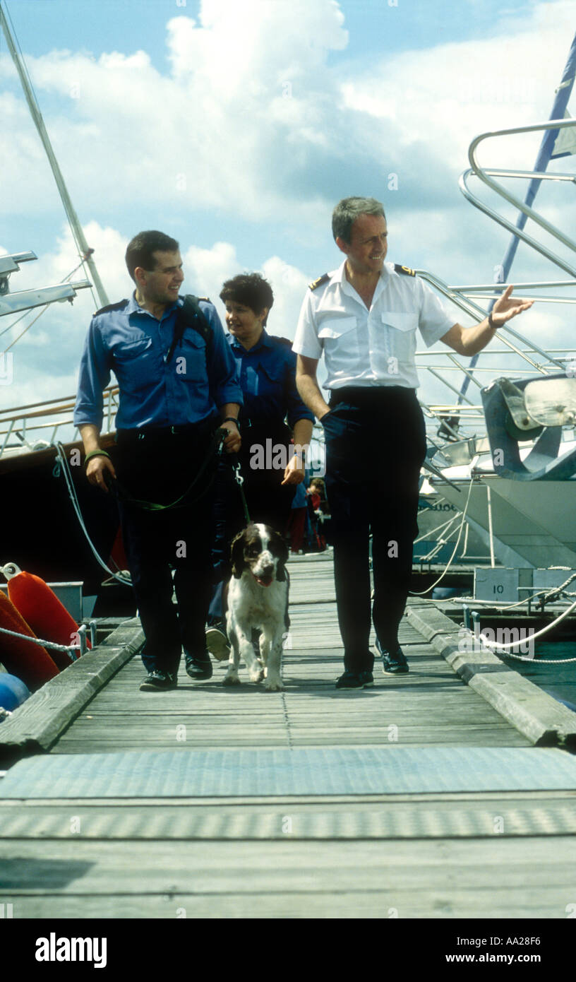 Customs and Excise officers patrol a yacht marina with a sniffer dog ...