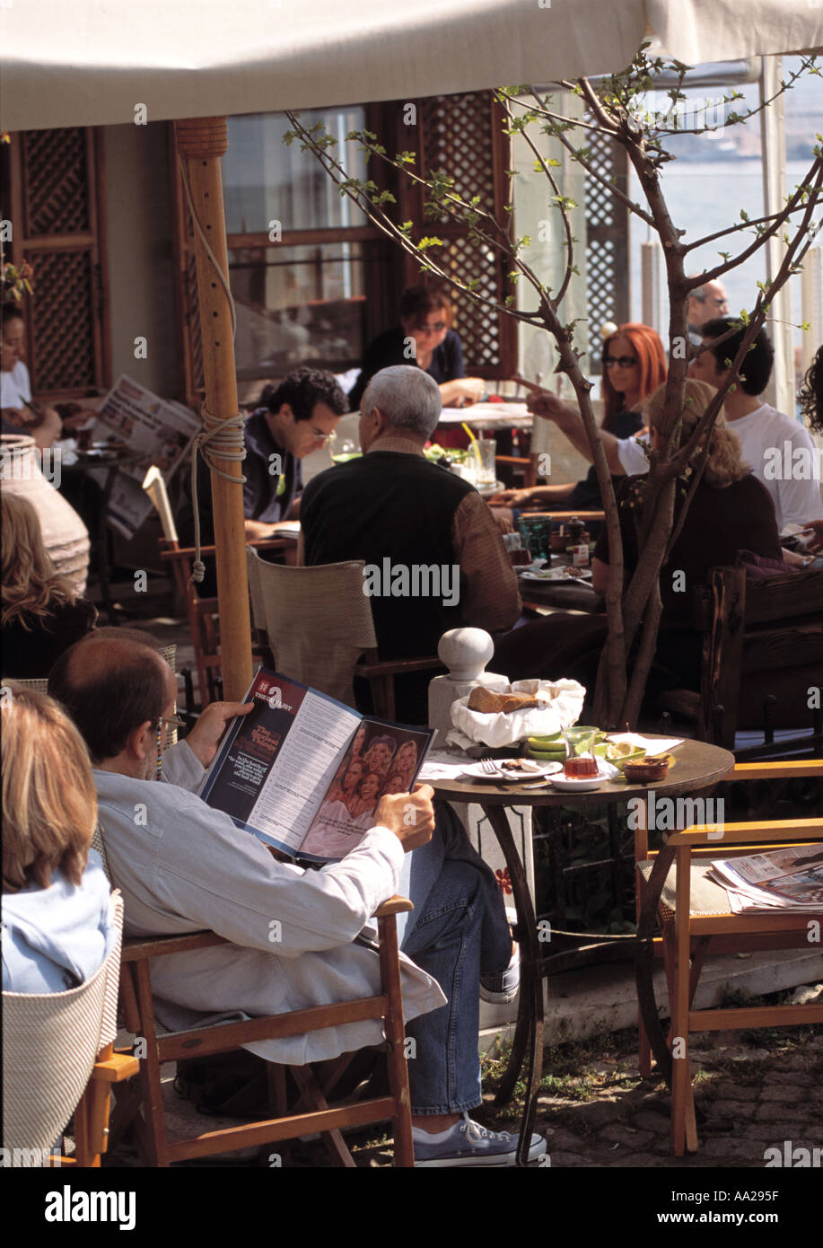 man reading newspaper in cafe beside Bosphorus Stock Photo - Alamy