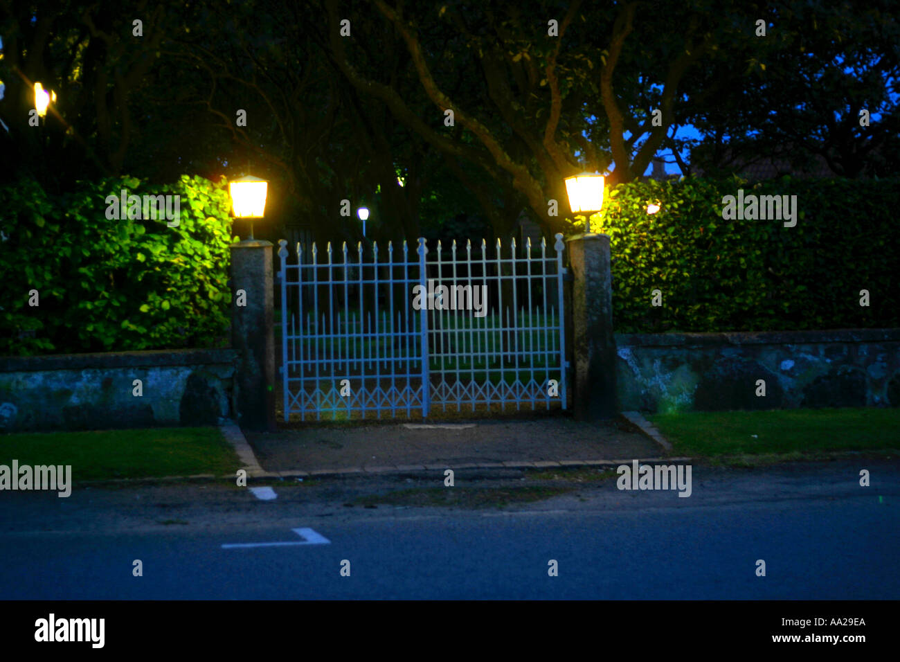 Street lights of a garden gate illuminated at night Stock Photo - Alamy
