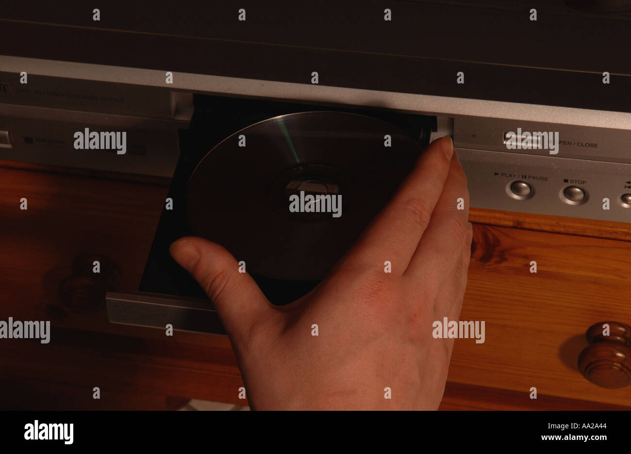 hand putting dvd into dvd player Stock Photo - Alamy