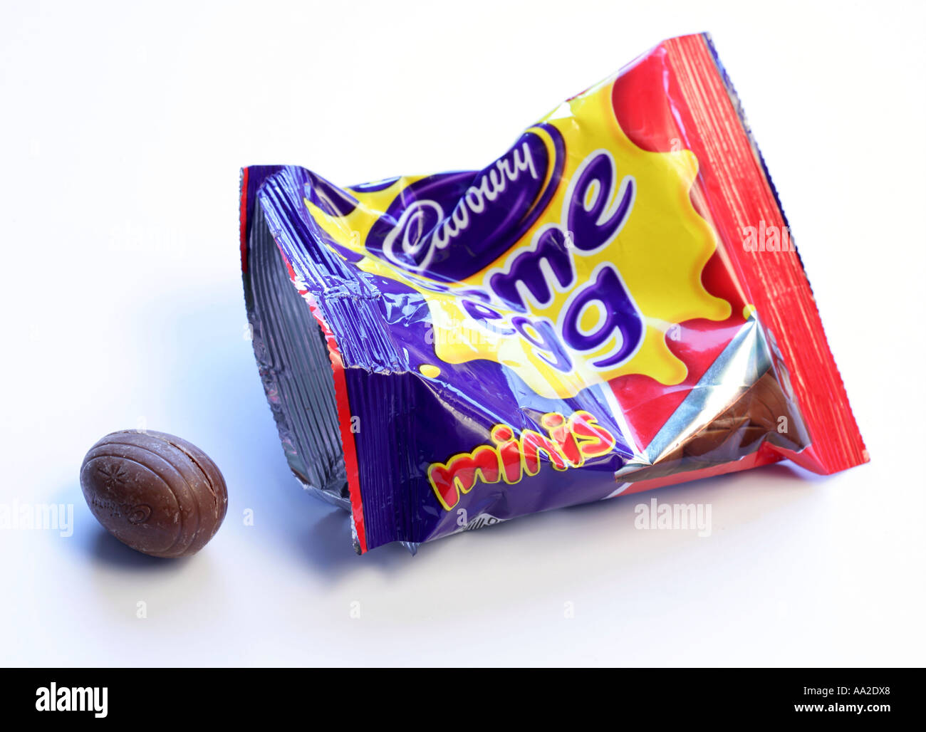 A packet of cadburys mini creme eggs with one egg out of packet against ...