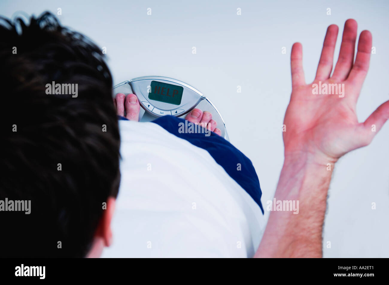 Man on scale Stock Photo - Alamy