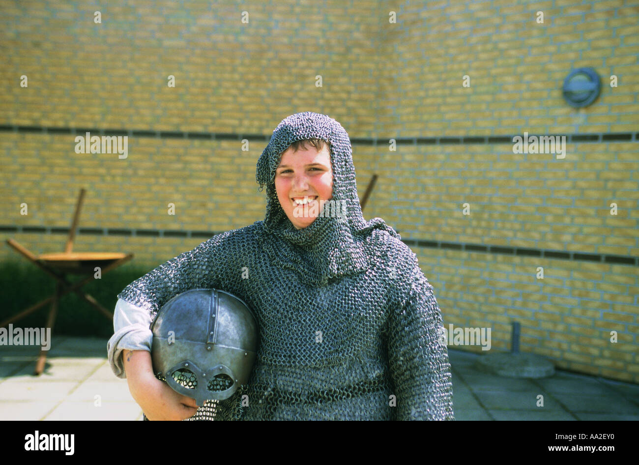 Denmark, Trelleborg, boy (14-15) wearing chain mail, smiling, portrait ...
