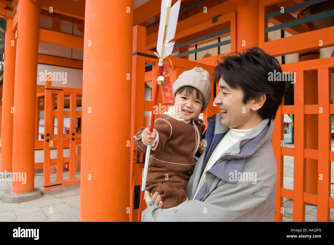 Father carrying son holding arrow Stock Photo - Alamy