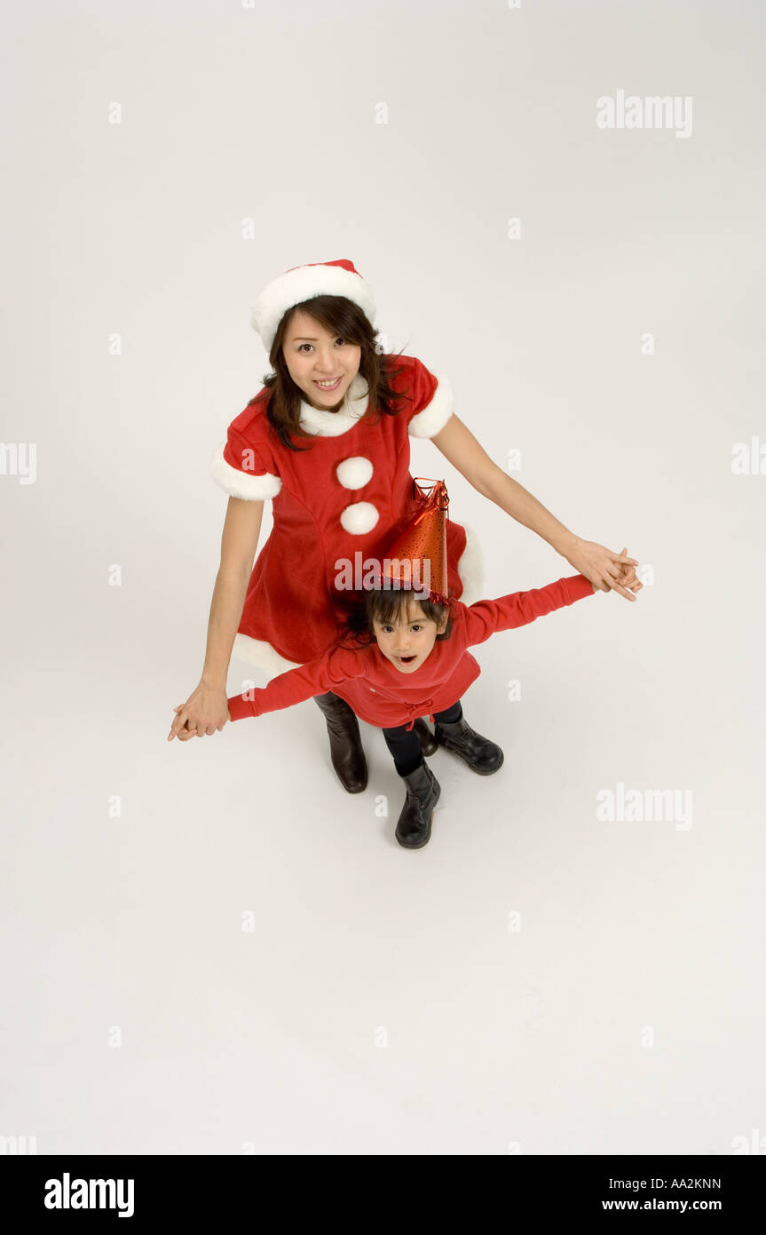 Mother in Santa outfit standing with daughter Stock Photo - Alamy