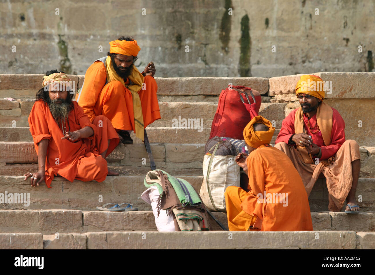 Four holy men sit and talk on he banks of the Ganges Stock Photo - Alamy