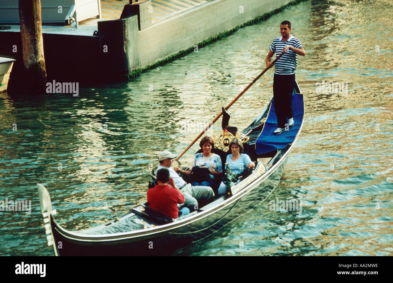 Italy, Venice, Gondoliere on gondola, gondolier punting with tourists ...