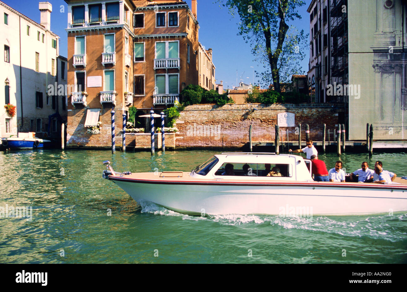 Italy, Venice, Grand Canal, pleasure boat passing brown building in ...