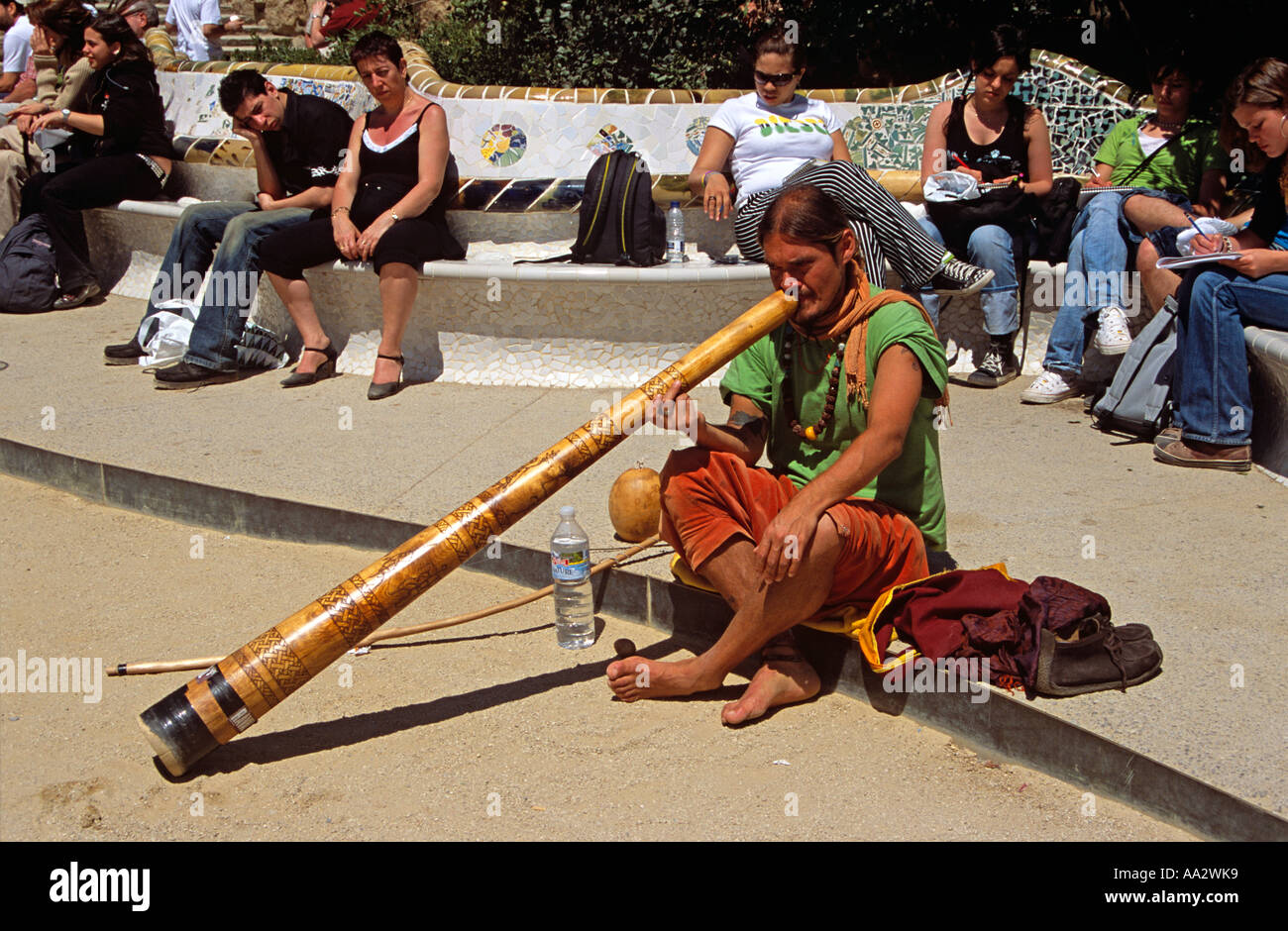 Man playing didgeridoo in front of famous Gaudi ceramic park bench ...