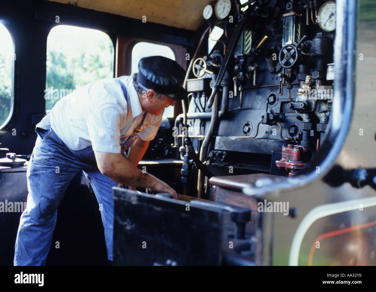 Steam Train driver putting coal in fire At Sherringham in Norfolk Uk ...