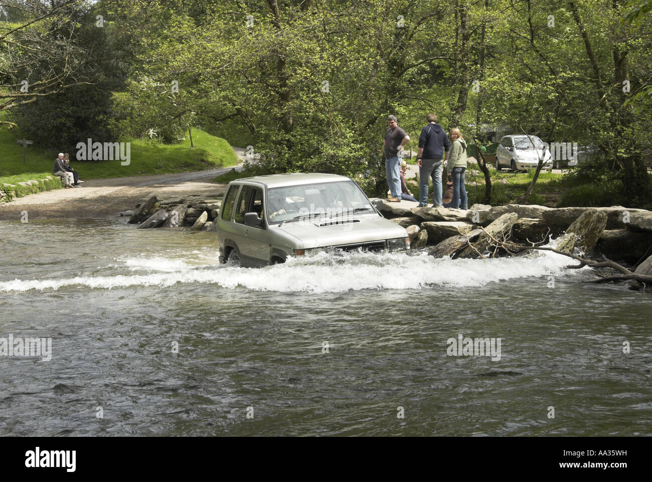 Four wheel drive vehicle driving through countryside river ford UK May ...