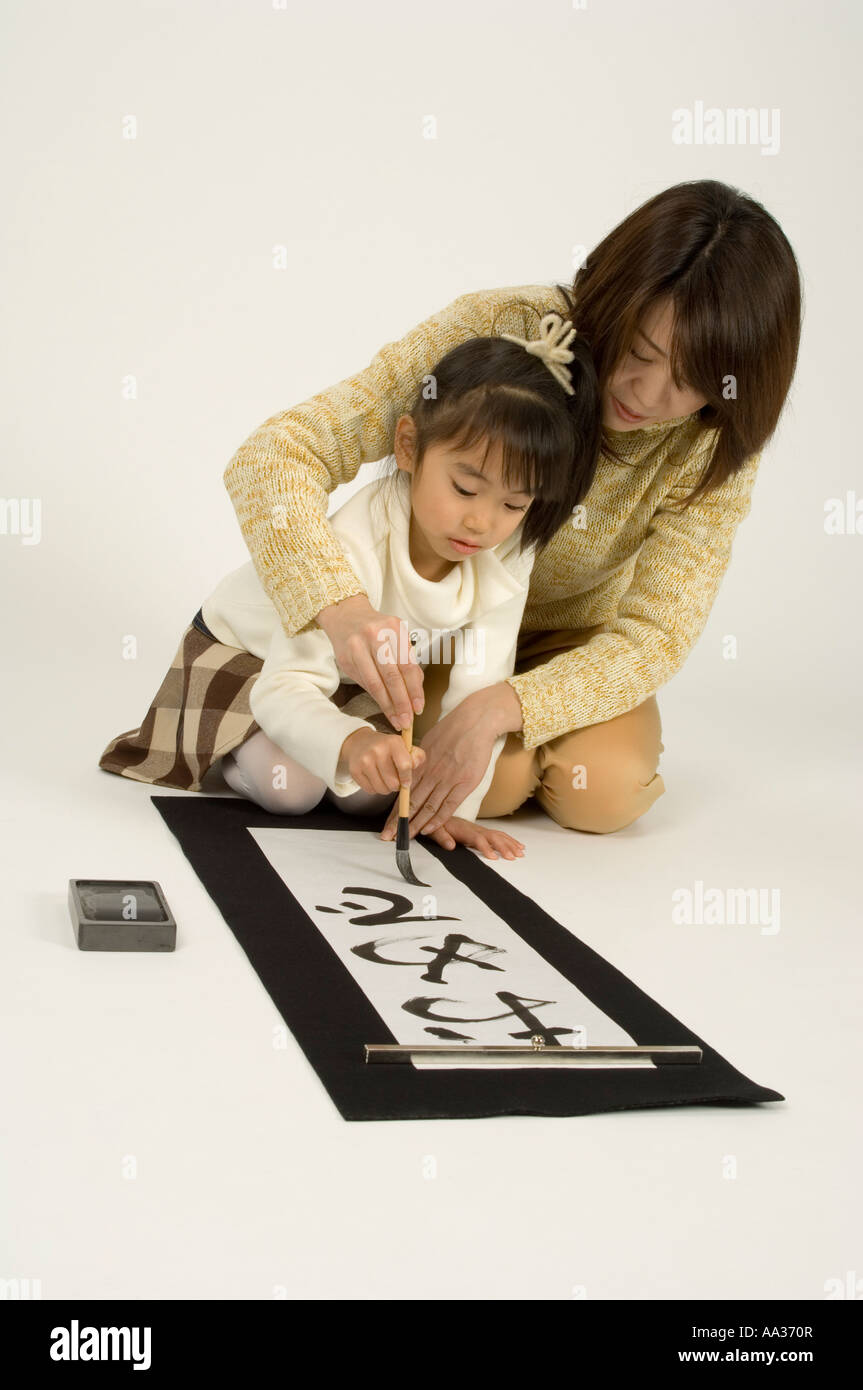 Mother and daughter writing letters with ink brush Stock Photo - Alamy