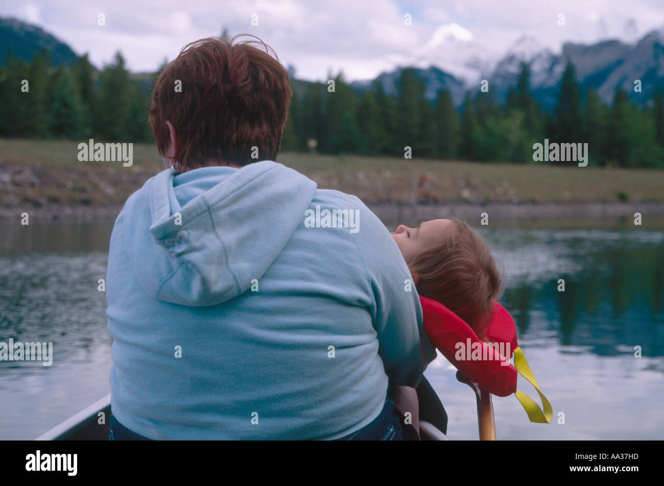 Girl sleeping in her mothers arms in a canoe Banff National Park Stock ...