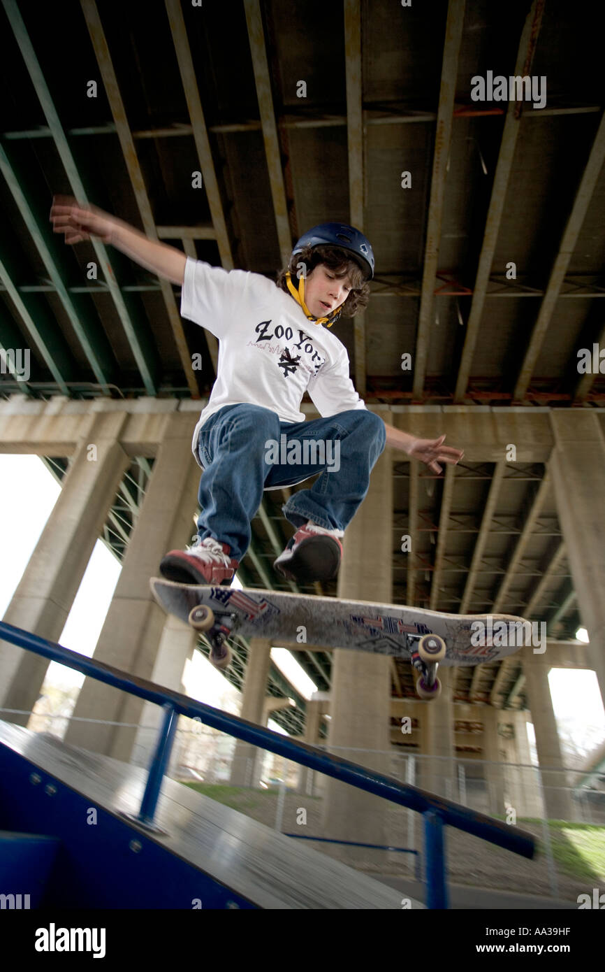 Boy jumping off a rail on a skateboard with helmet. Teens. Teenagers ...
