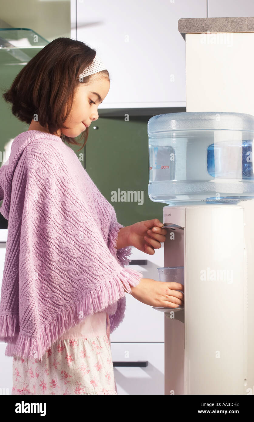 Child getting drink from a water cooler in the kitchen Stock Photo - Alamy