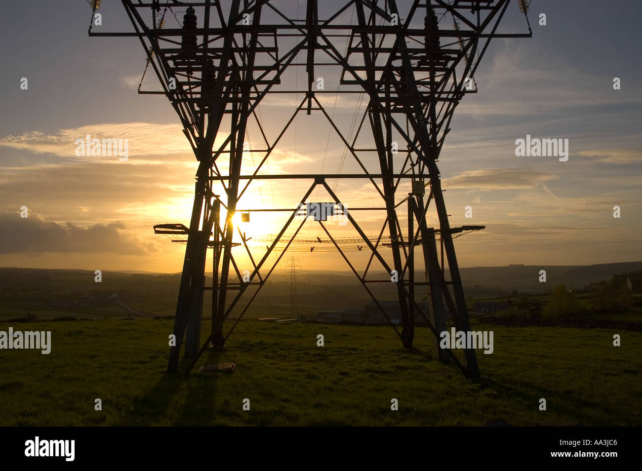 Sun setting behind electricity pylon Stock Photo - Alamy