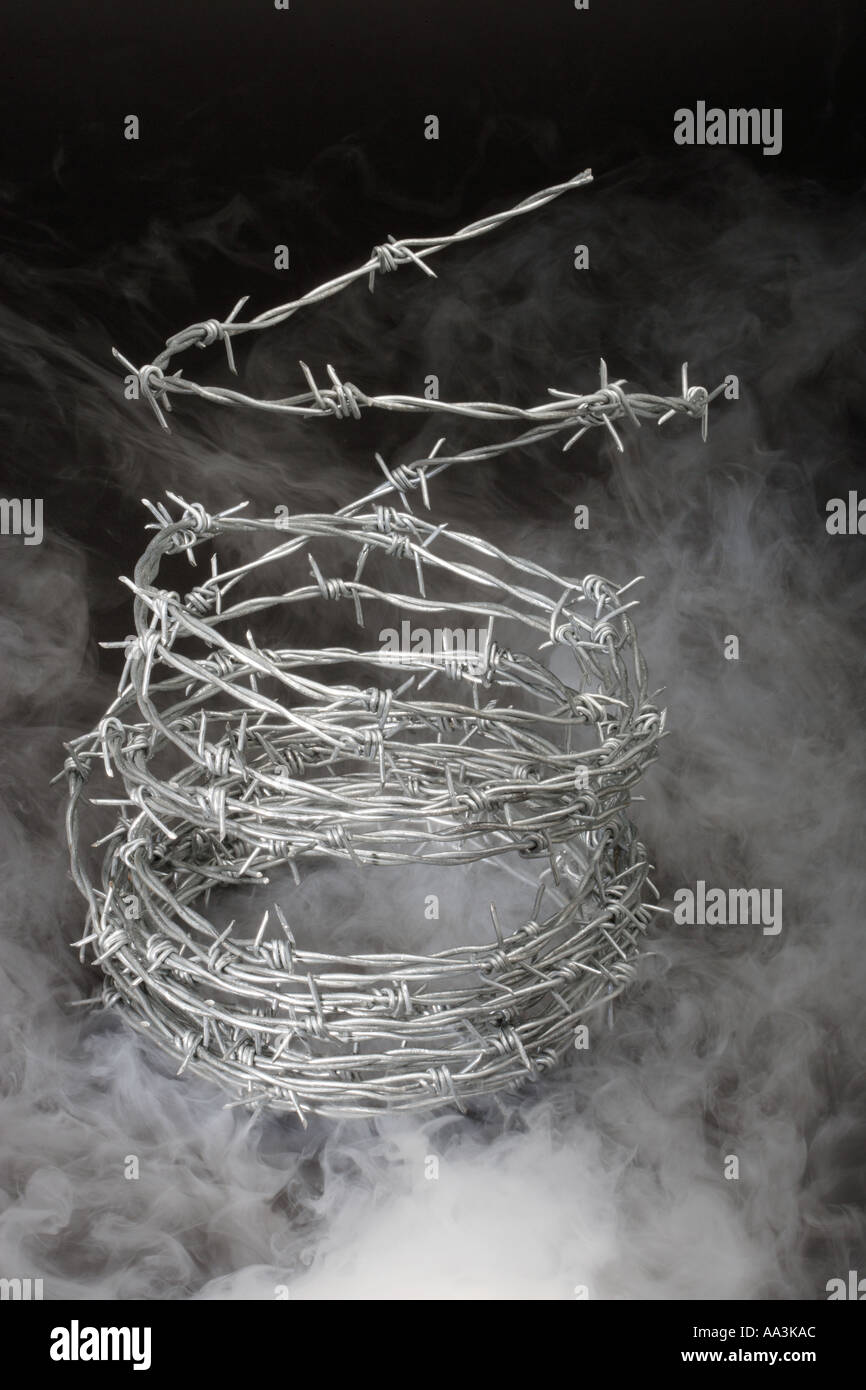 Barbed wire coil and smoke Stock Photo - Alamy