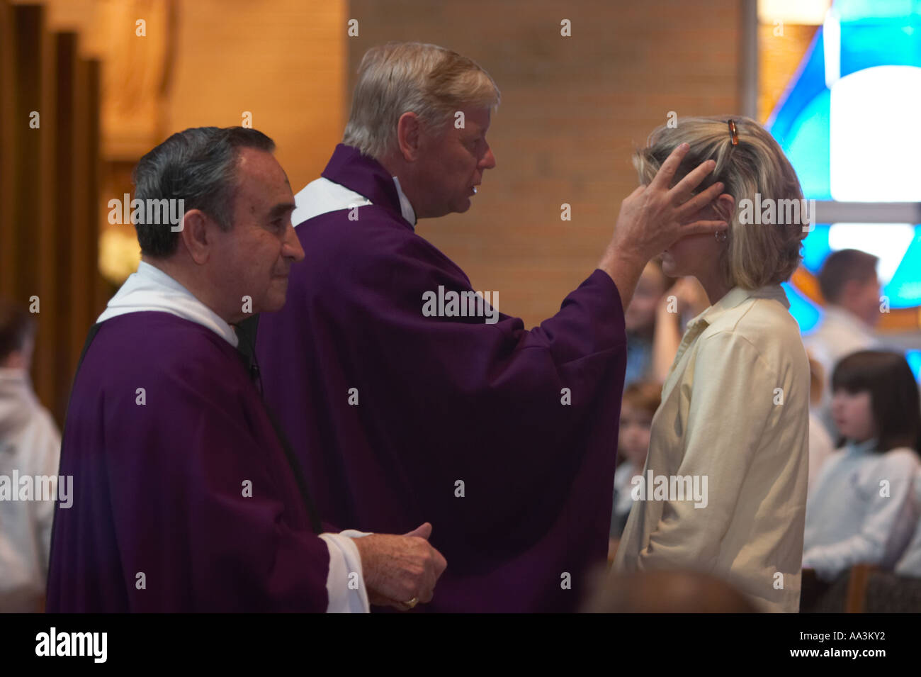 A priest applying the Ash Wednesday Ashes to a woman's forehead Stock ...