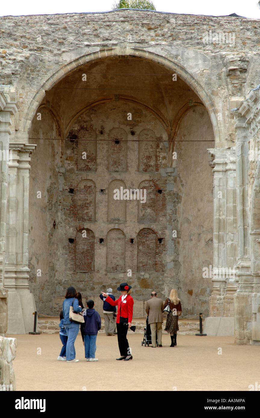 Guide with tourists at the Great Stone Church Mission San Juan ...