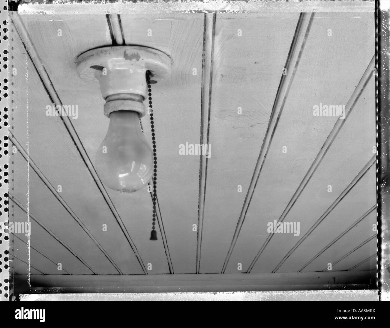 Black White Photo of a single light bulb fixture on the ceiling of an ...