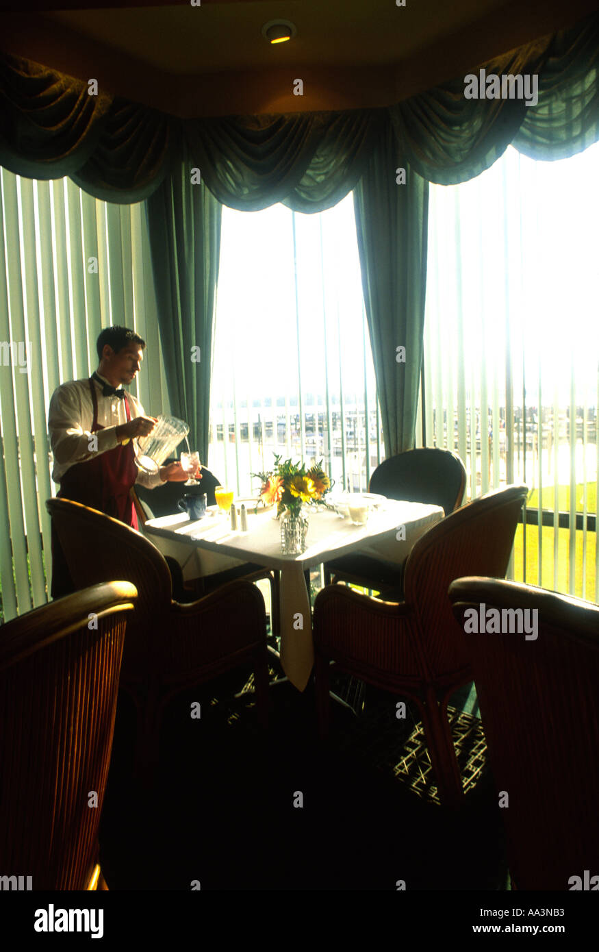 A waiter at a beach resort fills up a water glass Stock Photo - Alamy