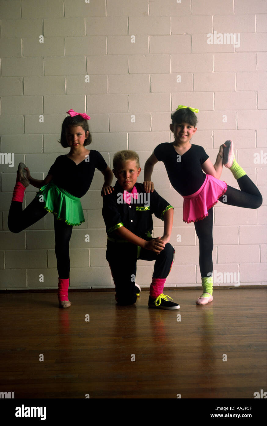 Three excited young kids pose for a portrait in a backstage green room ...