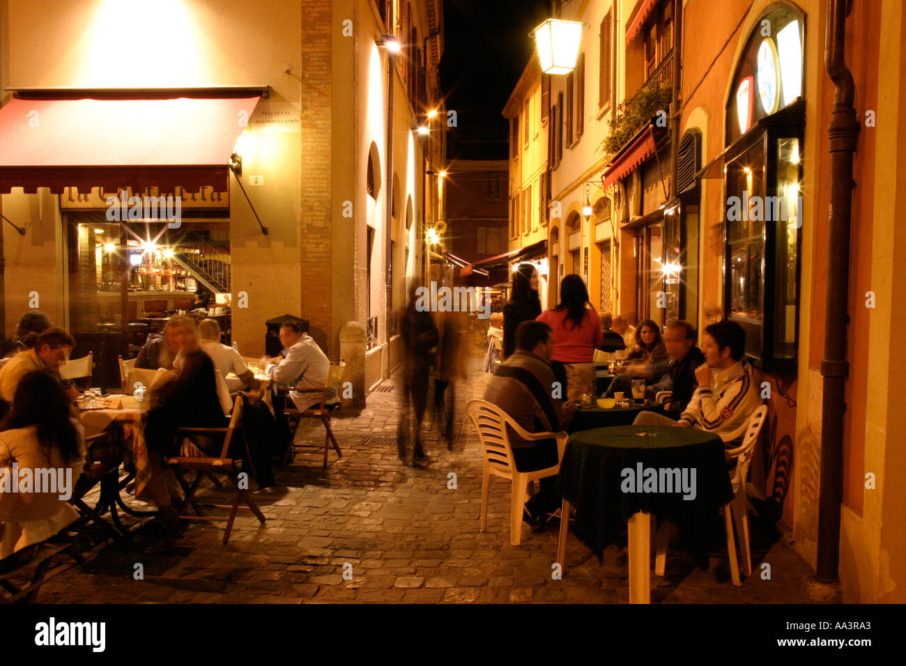 People eating and drinking outside cafes and restaurants in Rimini city ...