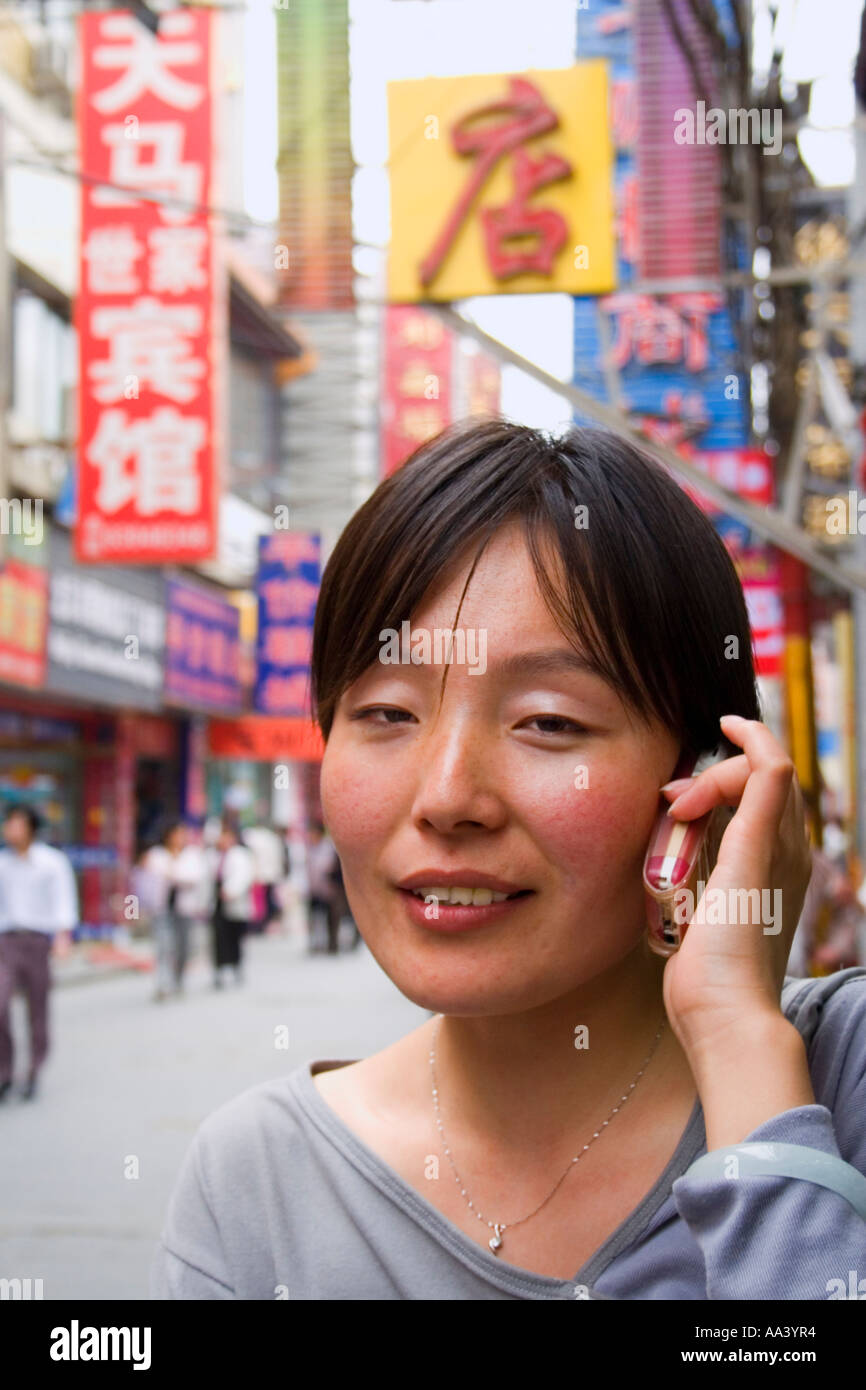 Beautiful young Chinese woman deep in conversation talking on cellphone ...