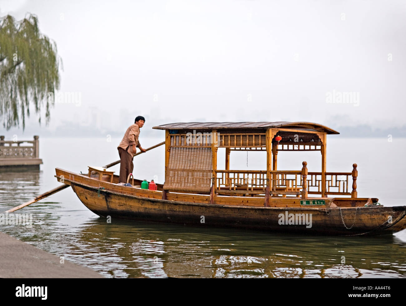 CHINA HANGZHOU Boatman trolls for customers in his wooden tour boat ...